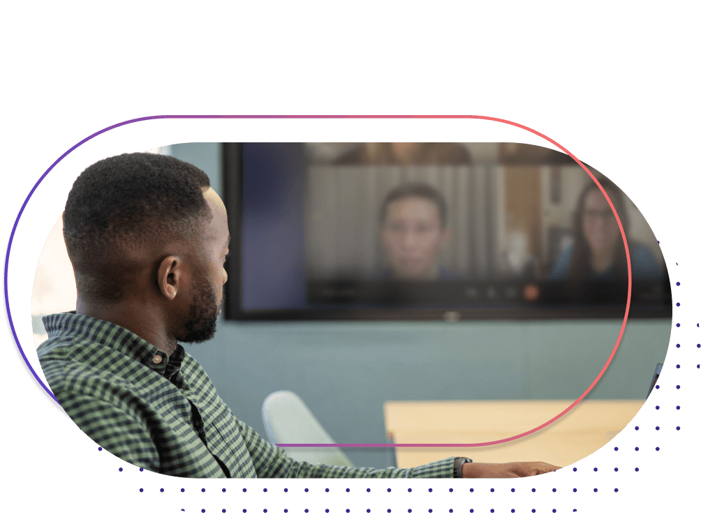 A man in a checkered shirt participates in a video conference in an office setting